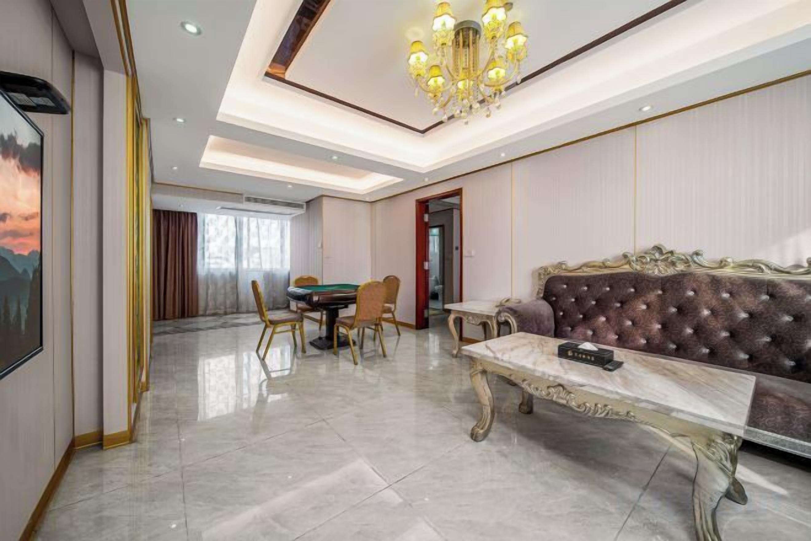 Ampla sala de estar com mesa de bilhar, sofá e mesa de jantar.