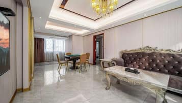 Ampla sala de estar com mesa de bilhar, sofá e mesa de jantar.