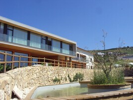 Um edifício moderno com parede de pedra e área de piscina.