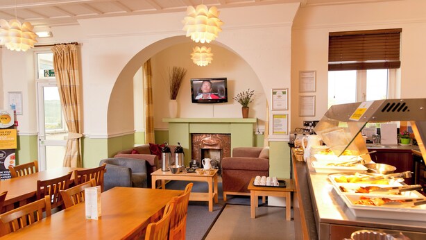 Um restaurante acolhedor com lareira, móveis de madeira e um espaço para buffet.