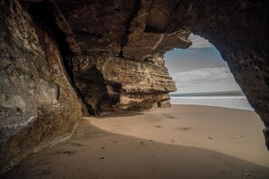 Praia particular, areia preta, espreguiçadeiras, toalhas de praia 