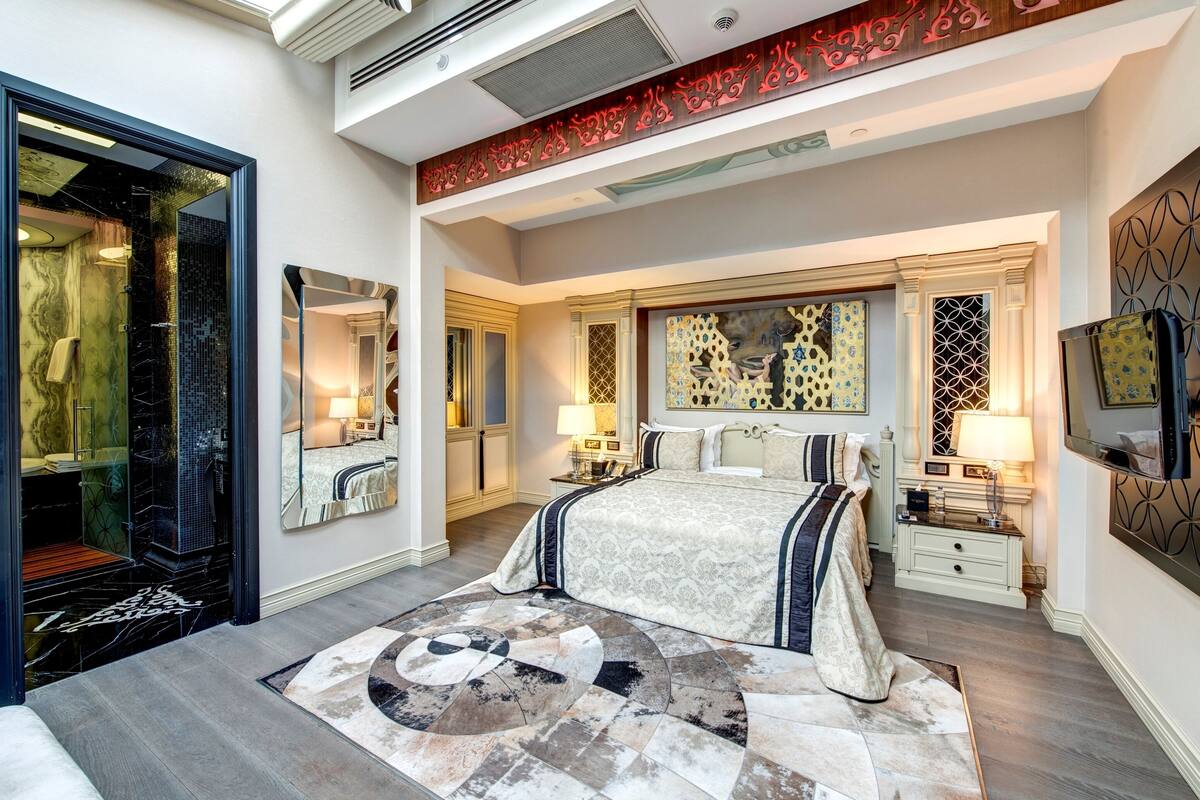 Um quarto espaçoso com uma cama grande, um closet amplo e um banheiro com porta de vidro.