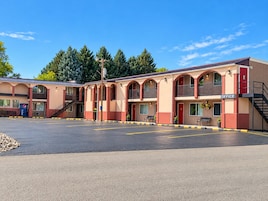 Um motel com vários quartos, estacionamento e uma pequena recepção.