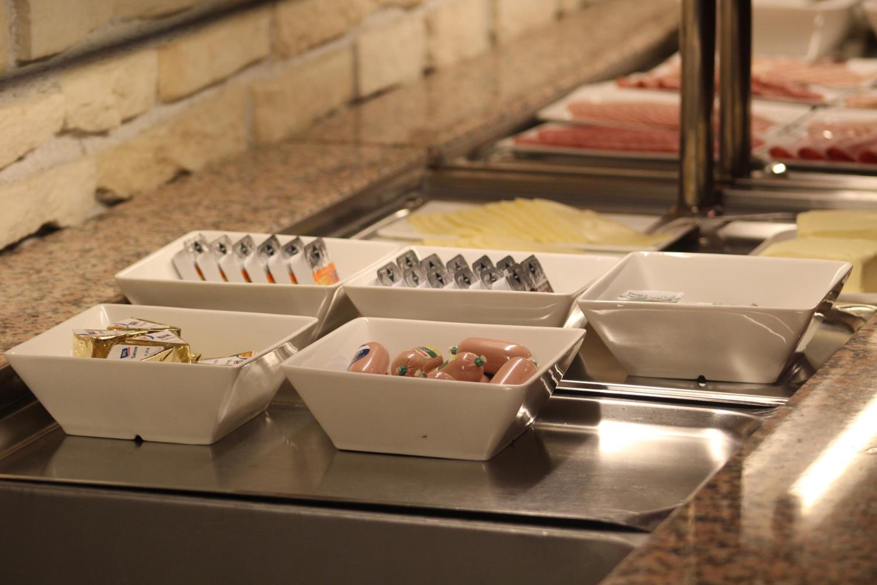 Disposição de buffet com diversos alimentos e acompanhamentos.