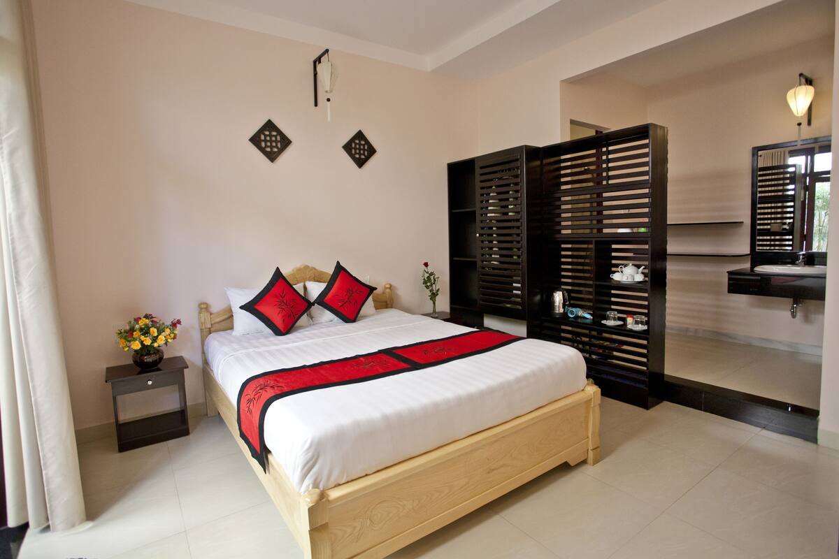 Quarto bem arrumado com cama, mesa de cabeceira e guarda-roupa.