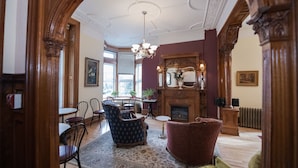 Quarto tradicional com lareira, móveis de madeira e um candelabro.