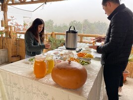 Mesa posta ao ar livre com comida, bebidas, um termo e uma abóbora.