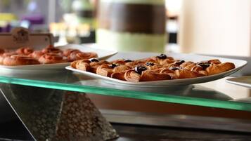 Uma mesa de vidro com uma variedade de doces e pastelaria.