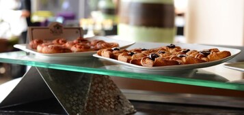 Uma mesa de vidro com uma variedade de doces e pastelaria.