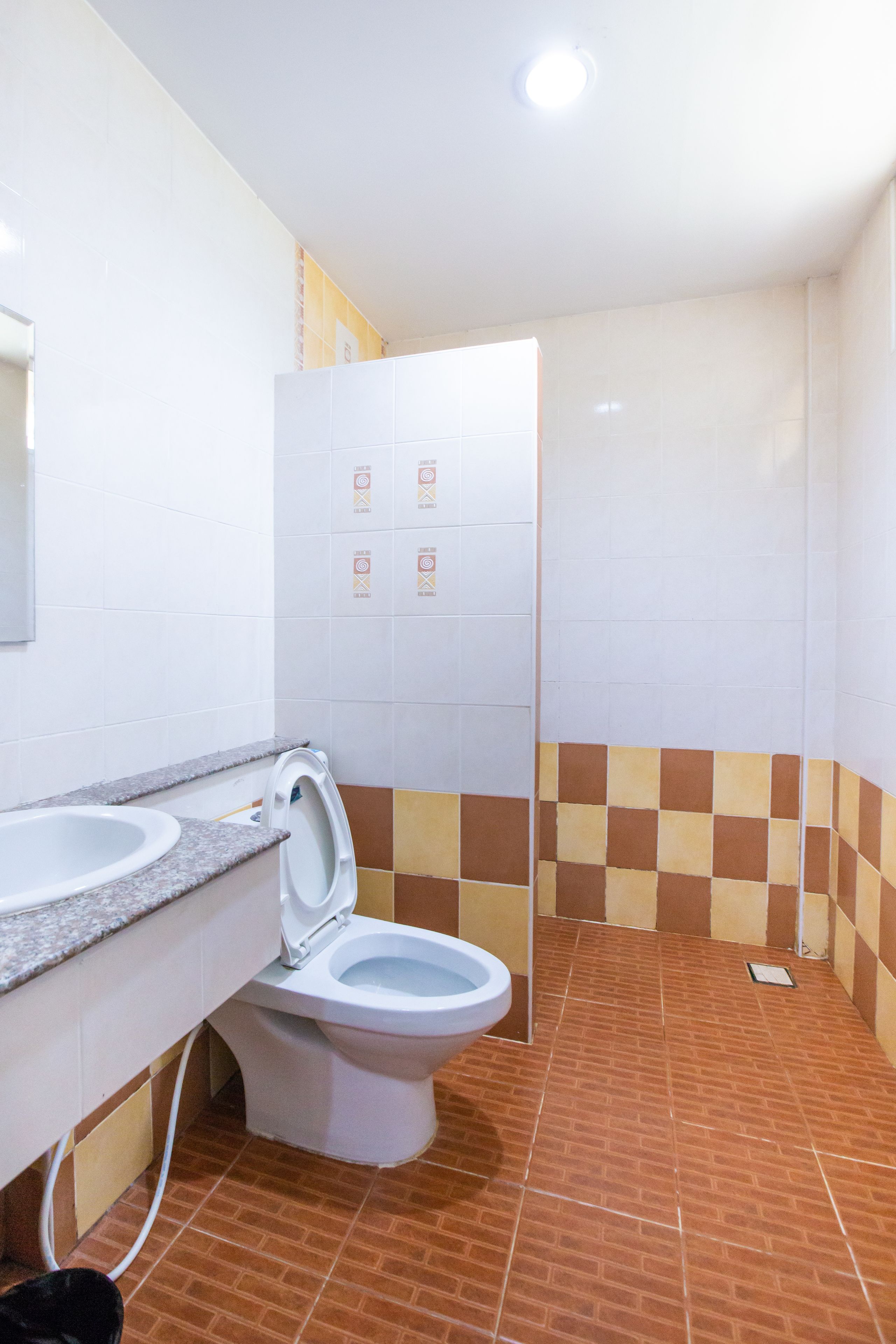 Casa de banho com sanita, lavatório e paredes em azulejo.