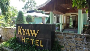 Placa do Hotel Kyaw com base de pedra e letras douradas.