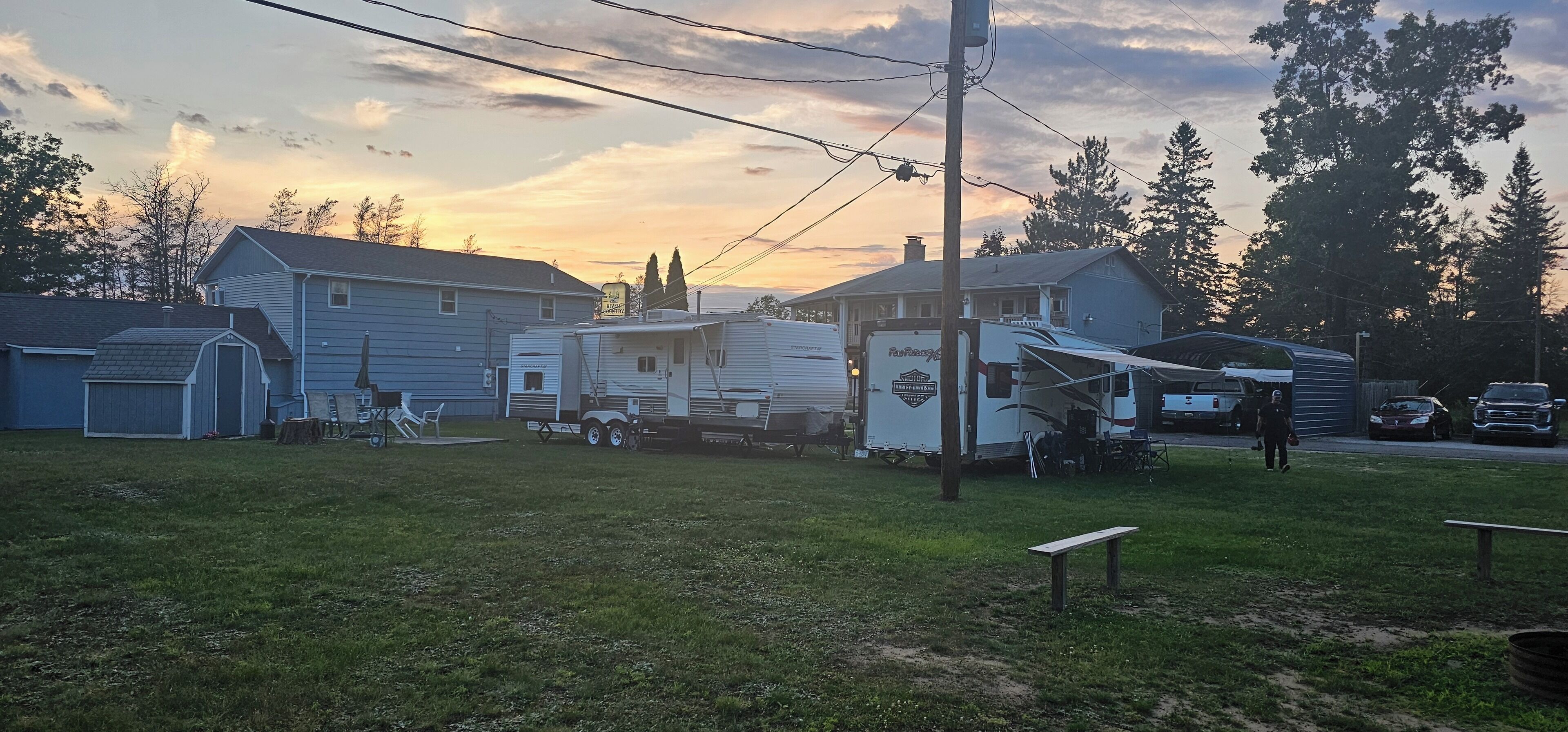 Uma área residencial com uma casa, uma casa móvel e um trailer.