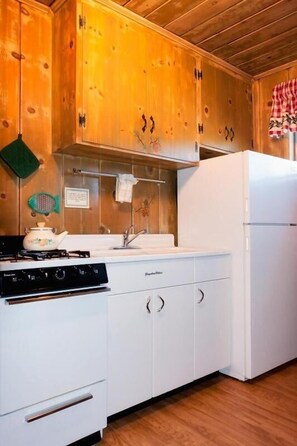 Um frigorífico, um micro-ondas, uma cafeteira/bule, uma torradeira 