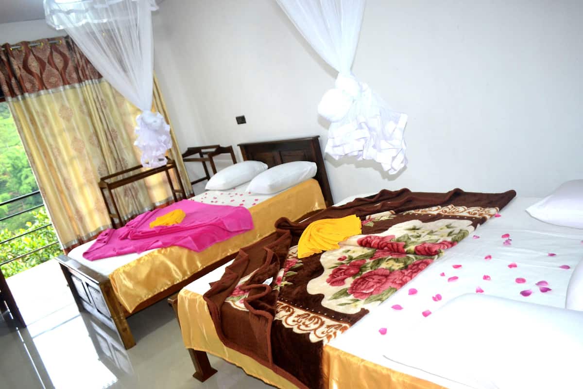Quarto de hotel com duas camas, varanda e vista para o verde.