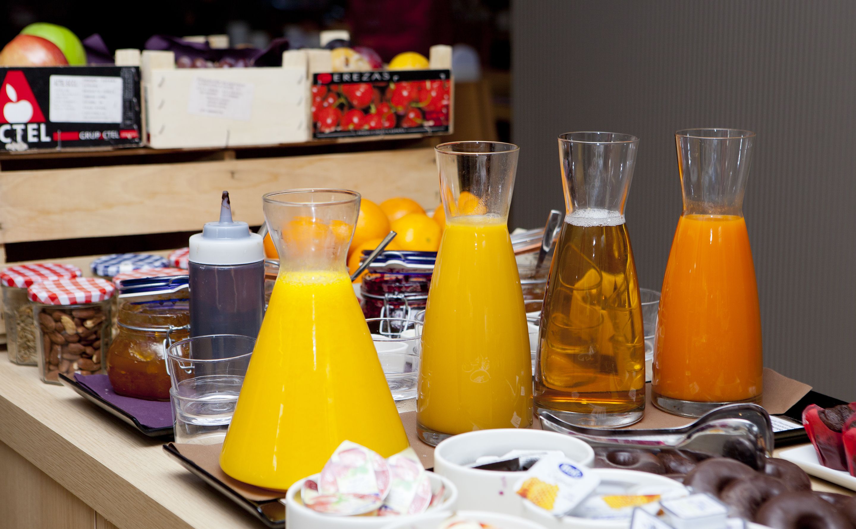 Buffet de café da manhã com diversas bebidas e opções de comida.