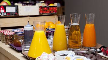 Buffet de café da manhã com diversas bebidas e opções de comida.