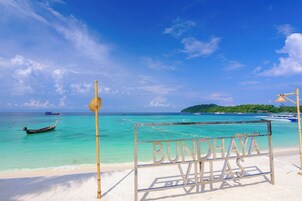 Na praia, espreguiçadeiras, guarda-sóis de praia, toalhas de praia 