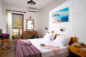 Quarto com cama, cômoda, mesa de cabeceira, janela com vista e um quadro na parede.