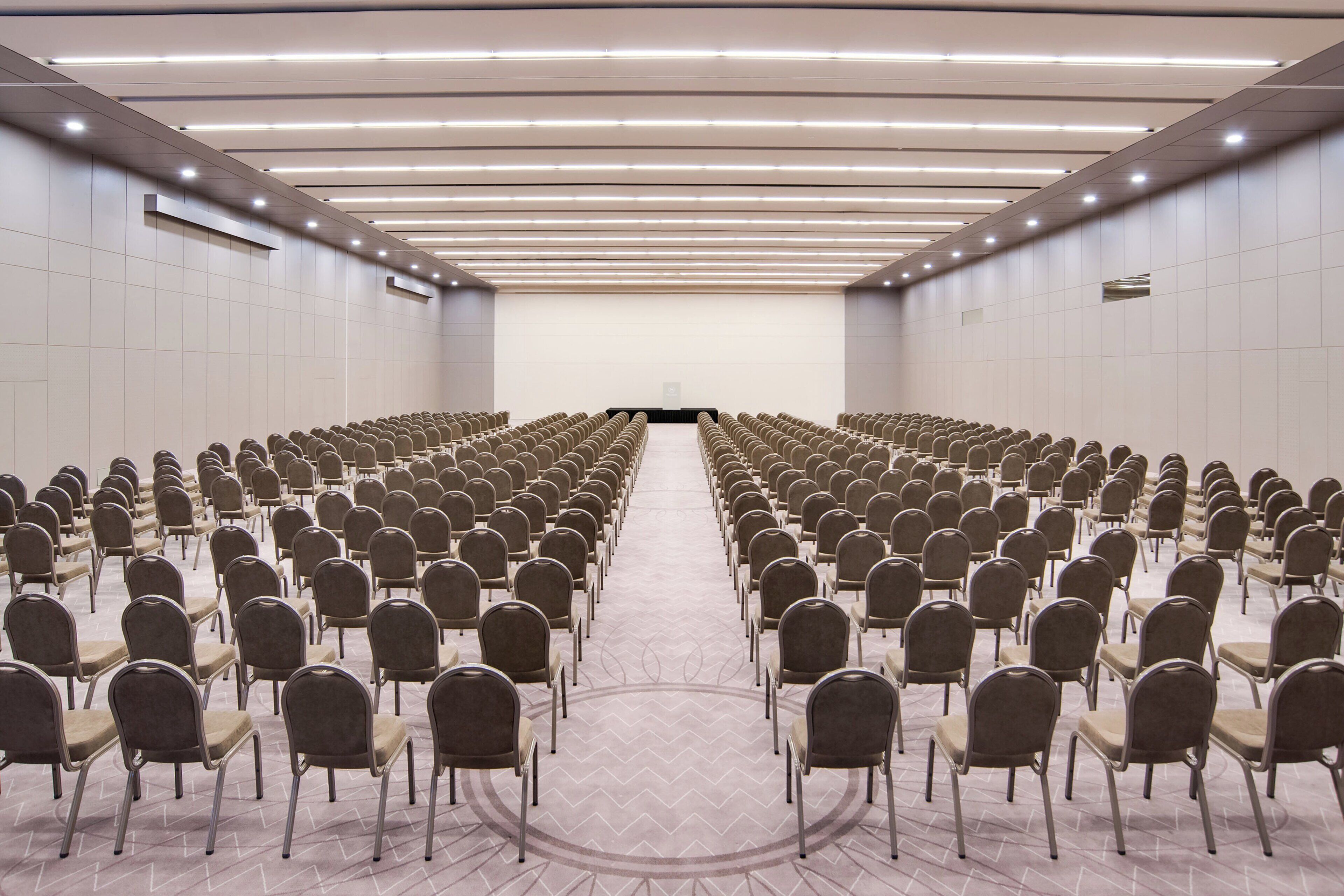 Uma sala de conferências com fileiras de cadeiras voltadas para um púlpito.