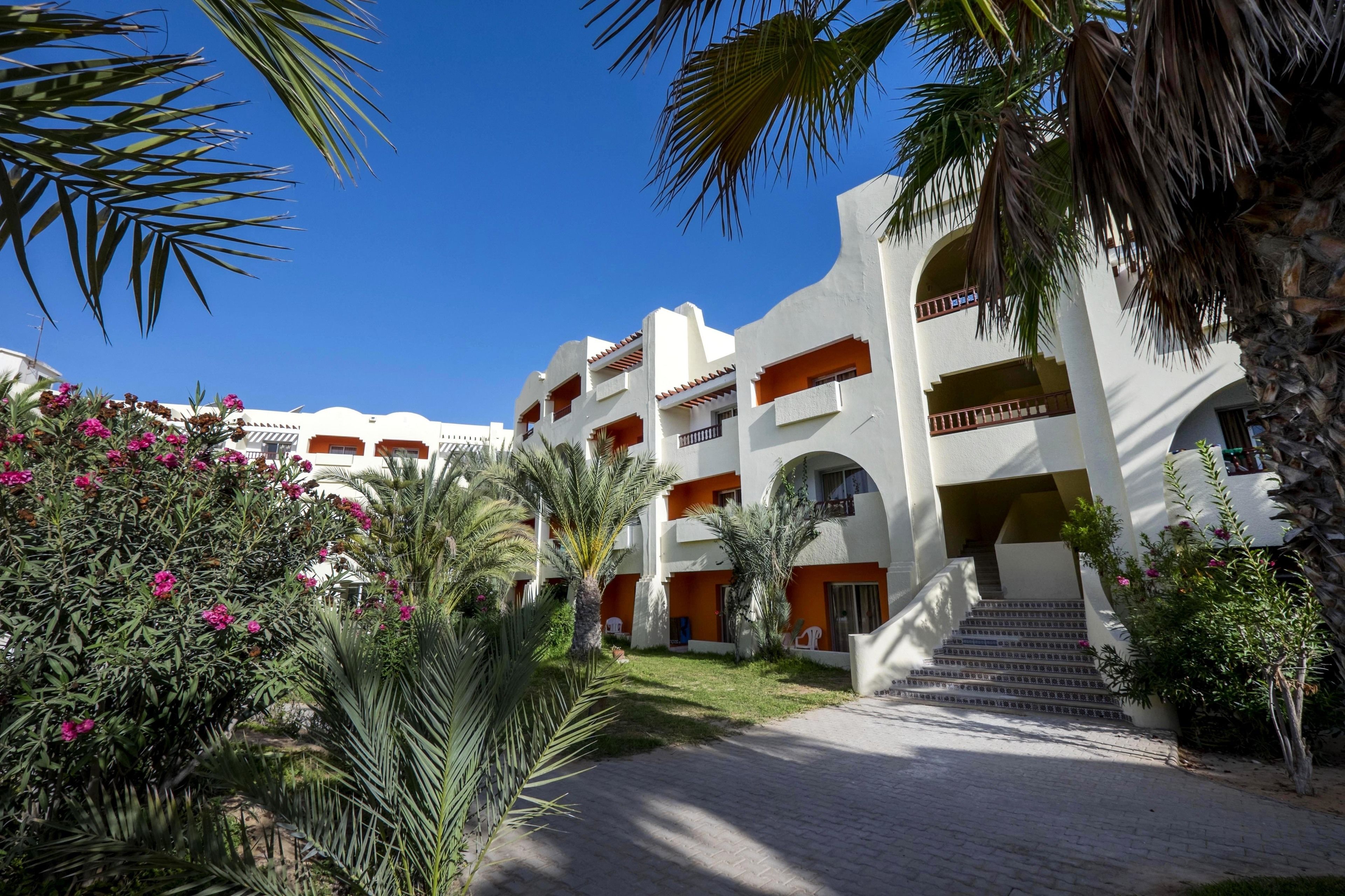 Um hotel de vários andares com varandas e um pátio central.