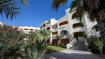 Um hotel de vários andares com varandas e um pátio central.