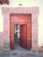 Uma porta de madeira grande com esculturas detalhadas, emoldurada por um arco de pedra.