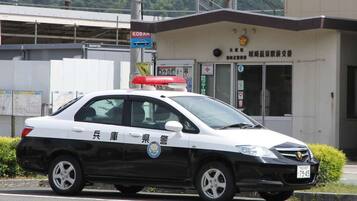 Um carro de polícia estacionado em frente a um edifício com uma placa que diz 'KOBAN'.