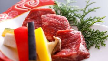 Um prato com carne crua, vegetais e um ramo de folhagem.