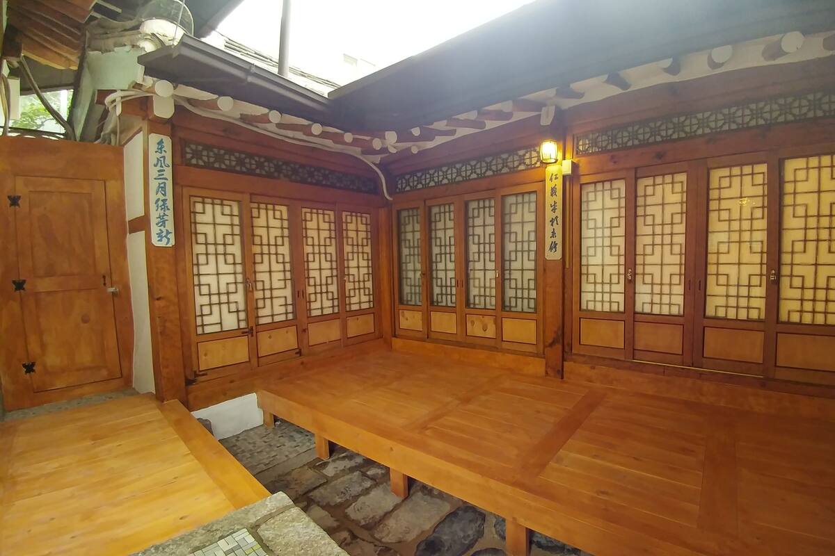 Um quarto japonês tradicional com tatames, portas deslizantes com padrões geométricos e um banco de madeira.