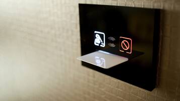 Painel de comando digital com ícones para casa de banho, Wi-Fi e placa de proibido fumar.