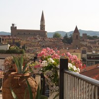 Vista de uma cidade histórica com edifícios importantes e uma torre de igreja.