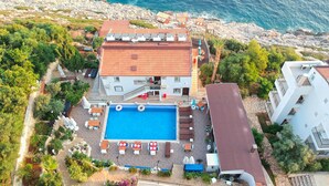 Um resort com piscina, área de estar externa e vista para o mar.