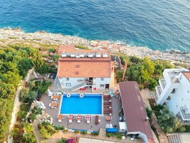 Um resort com piscina, área de estar externa e vista para o mar.