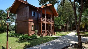 Uma casa de madeira com varanda e um caminho que a leva até ela.