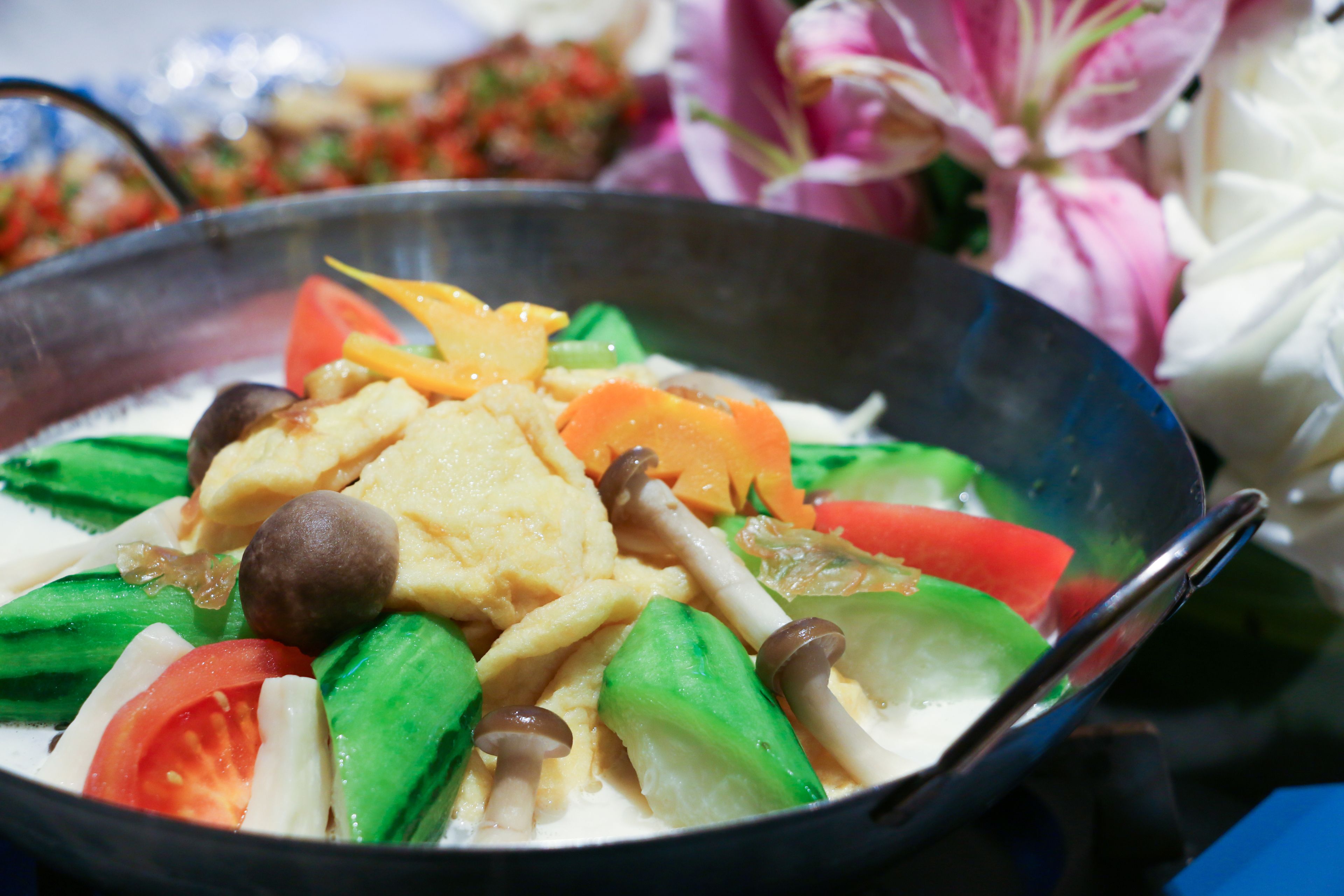 Uma tigela com legumes e tofu em uma frigideira.