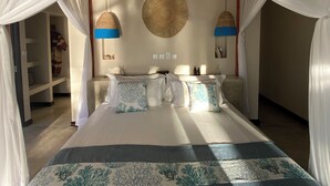 Quarto com cama de dossel, ventoinha no teto e duas luminárias fixadas na parede.