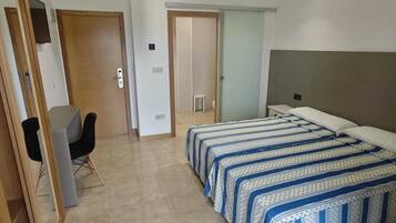 Um quarto com uma cama, uma escrivaninha e uma cadeira.