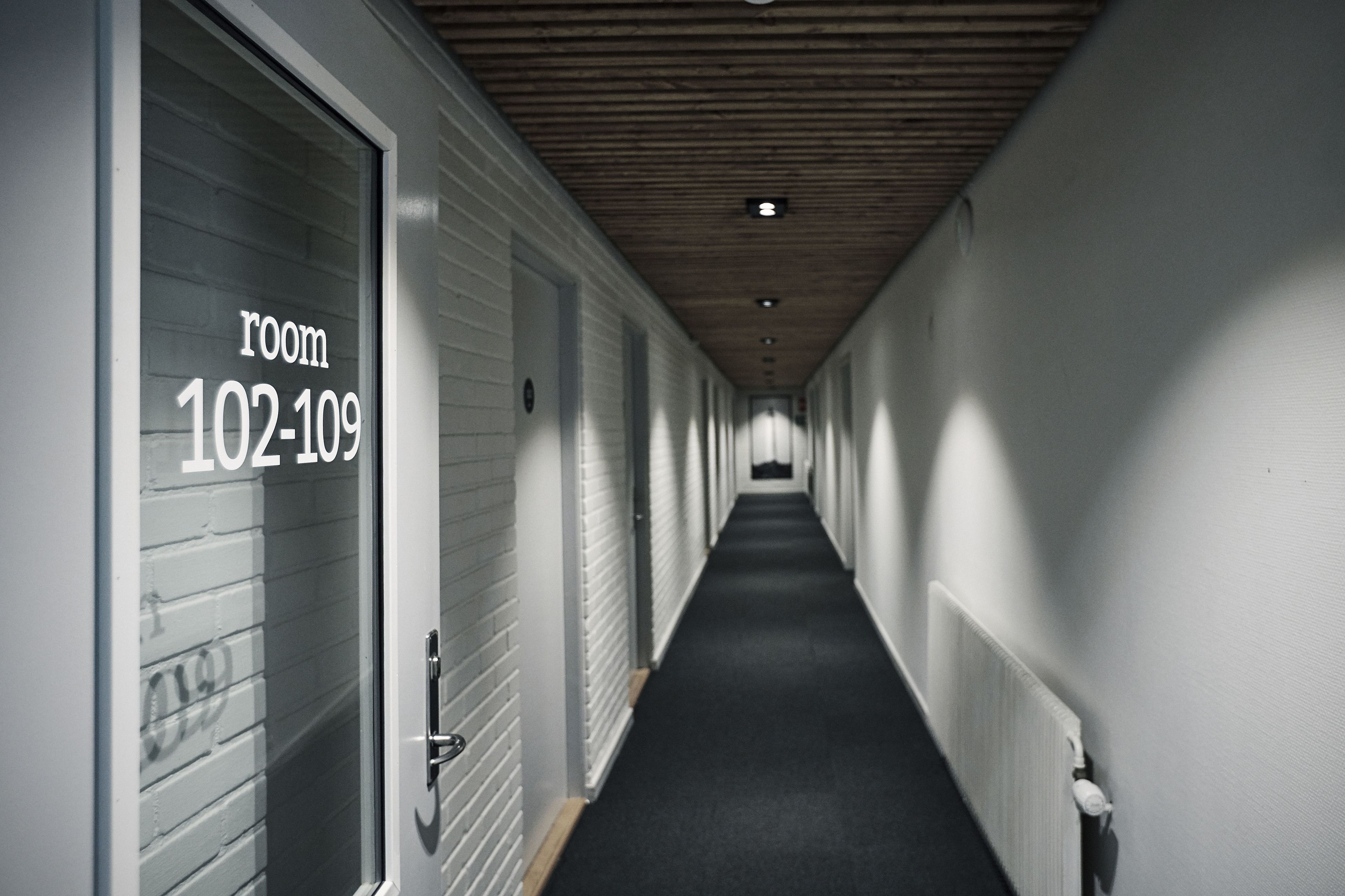 Corredor com portas identificadas como 'room 102-109'.