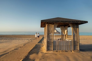 Uma praia privada, espreguiçadeiras, guarda-sóis de praia