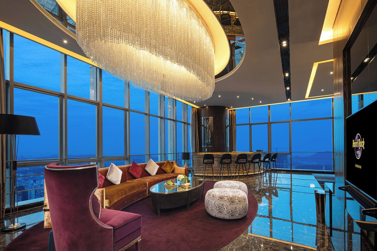 Um interior luxuoso com uma janela ampla, uma área de estar confortável, um bar e uma piscina.