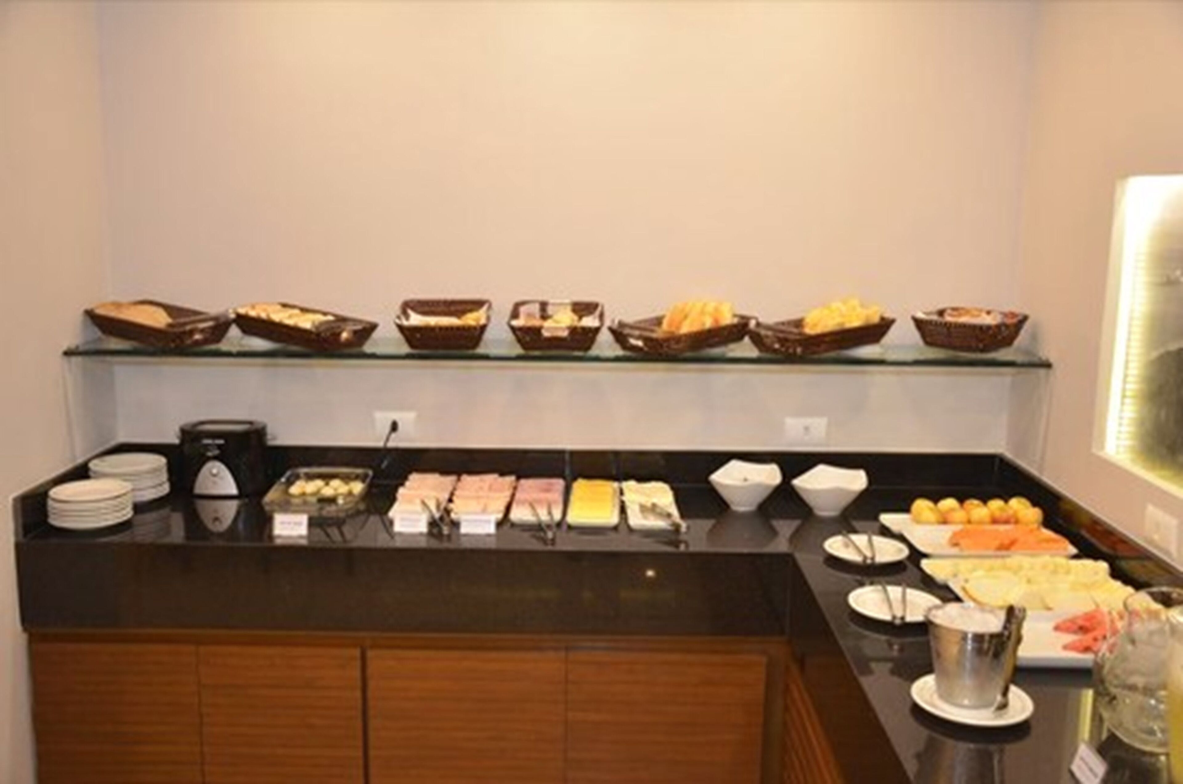 Disposição de buffet com diversos alimentos e utensílios.