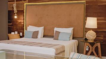 Quarto de hotel moderno com uma cama grande, uma mesa de vidro, uma cadeira de madeira e uma cabeceira de madeira.