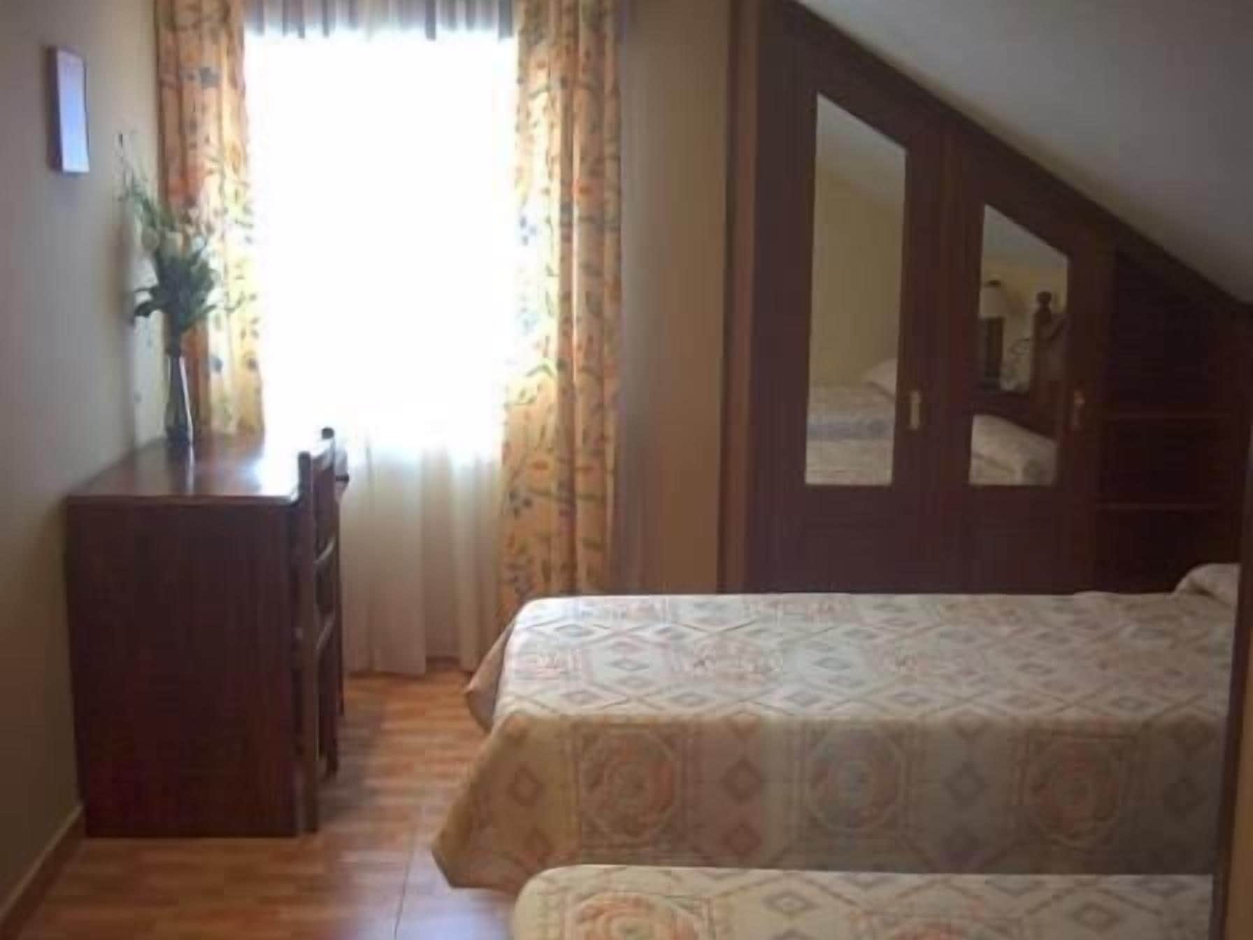 Quarto com cama, penteadeira e espelho.