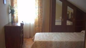 Quarto com cama, penteadeira e espelho.