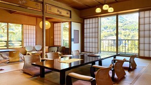 Quarto em estilo japonês tradicional, com tatames, uma mesa baixa e biombos shoji.