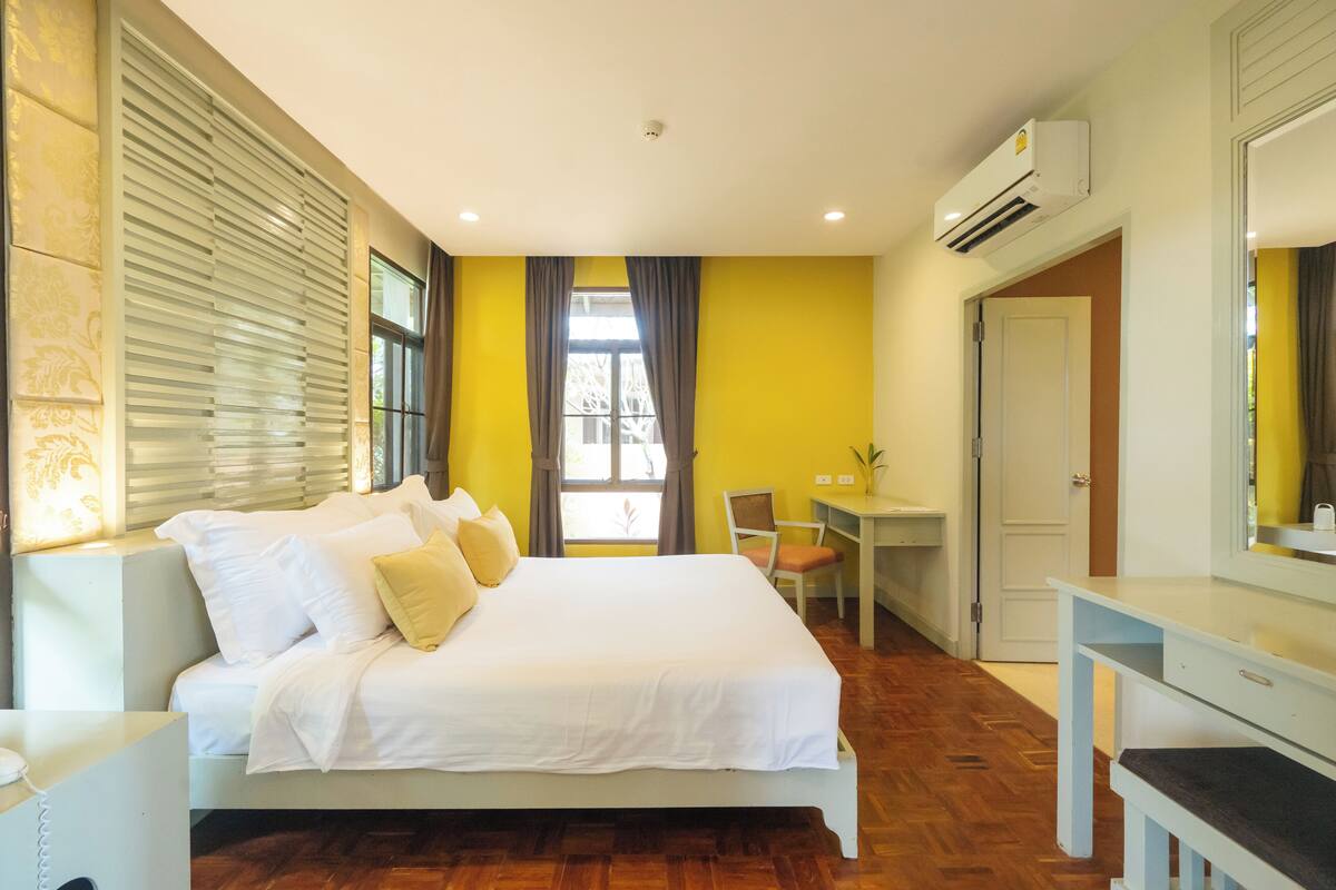Quarto de hotel com uma cama grande, uma mesa e uma cadeira.