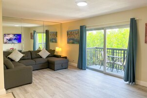 Apartamento família, 2 quartos | Área de estar | TV de tela plana 55 polegadas com canais a cabo, TV