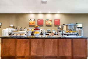 Um buffet de café da manhã com diversos alimentos e uma estação de café.