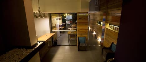 Interior moderno com área de refeições, cozinha e espaço de estar com vista para a rua.