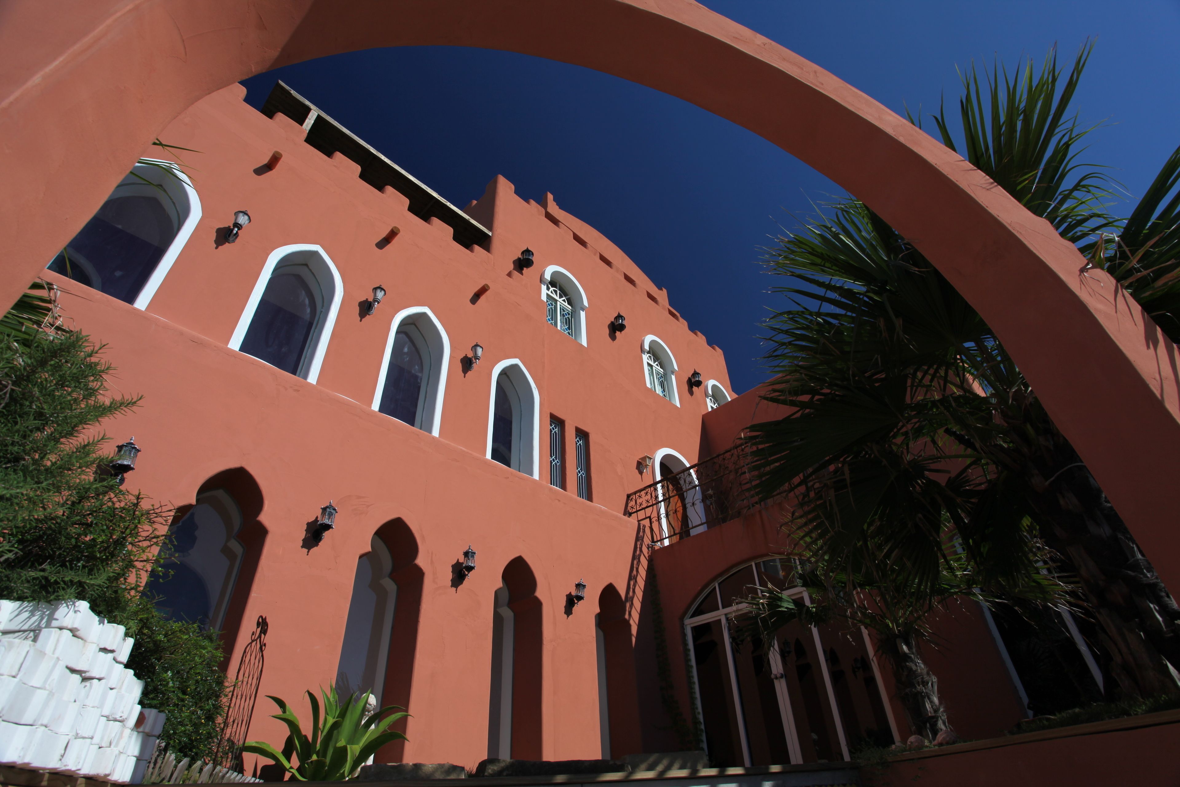 Um edifício com janelas em arco e entrada curva.
